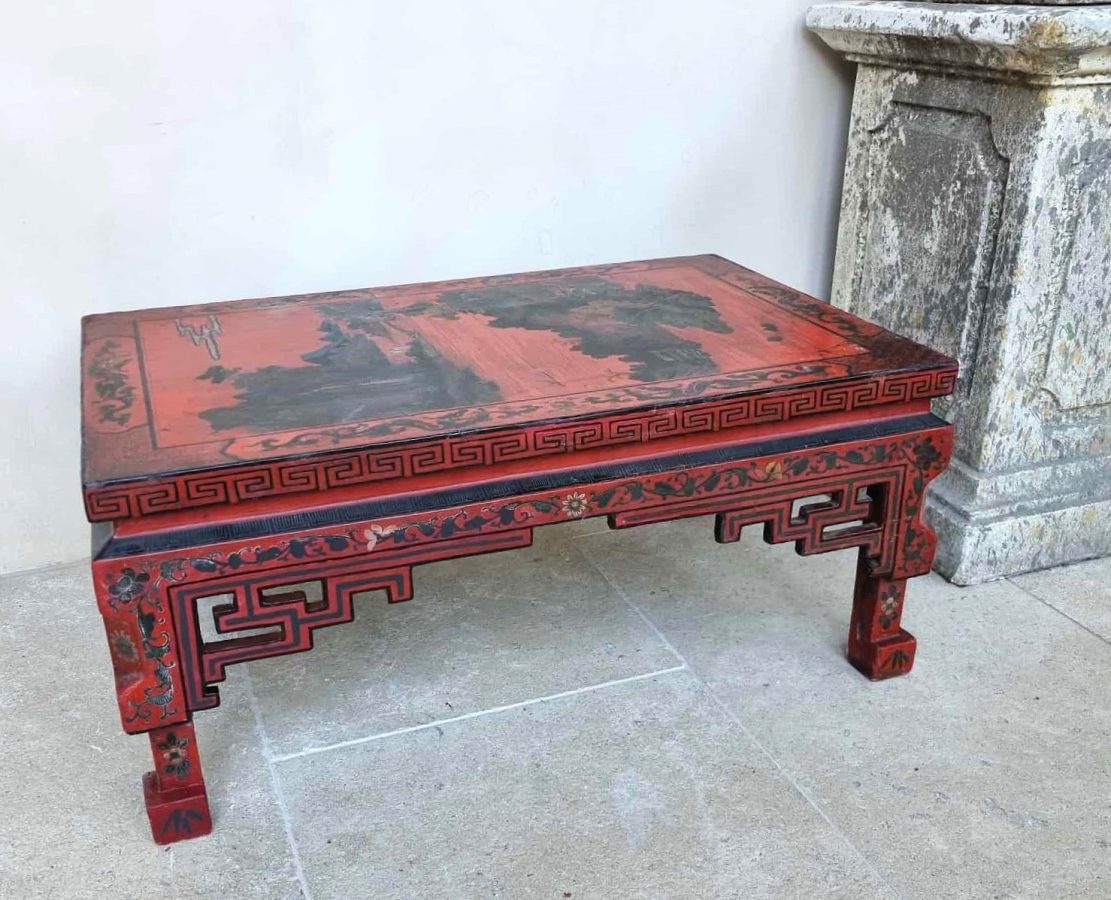 A striking red lacquered Chinese coffee table with fretwork detail to ...